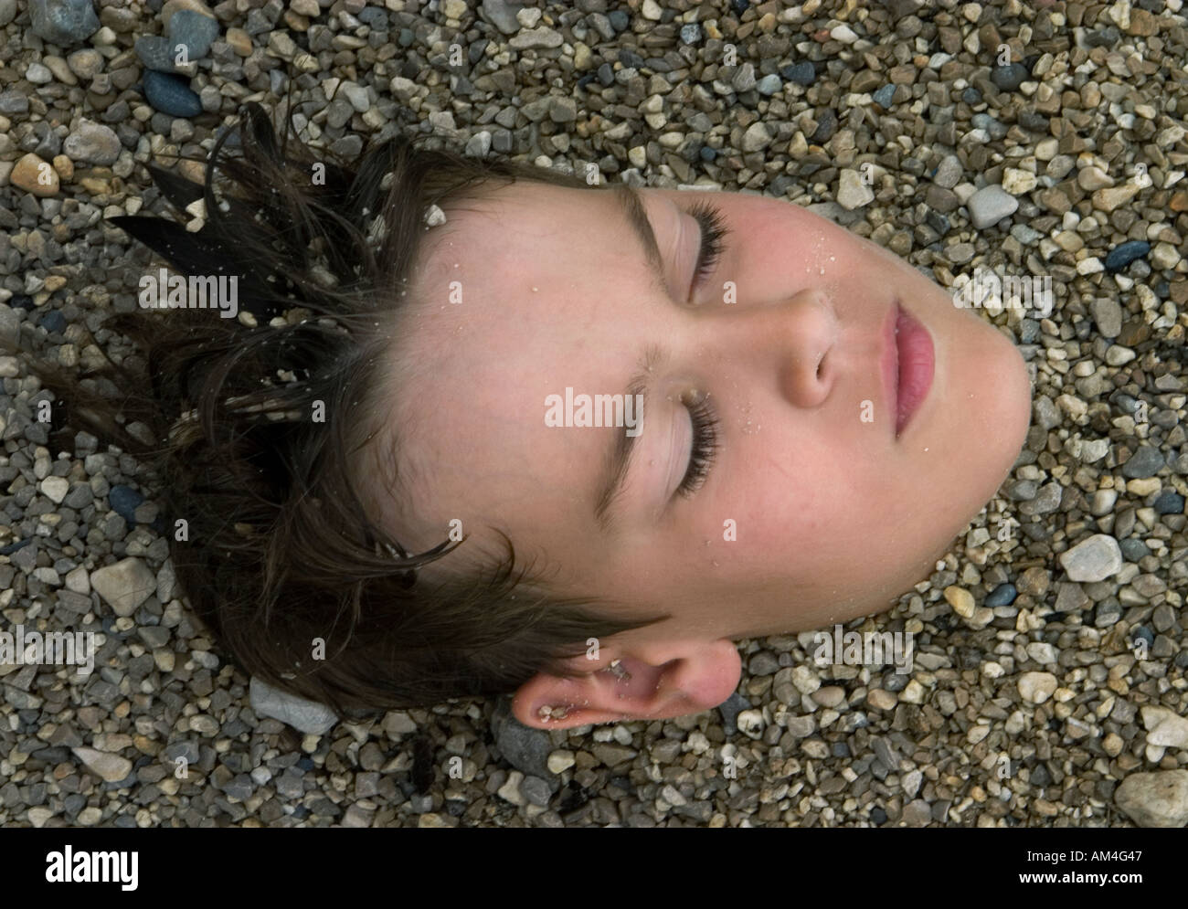 Boy Sleeping in Gravel Stock Photo - Alamy
