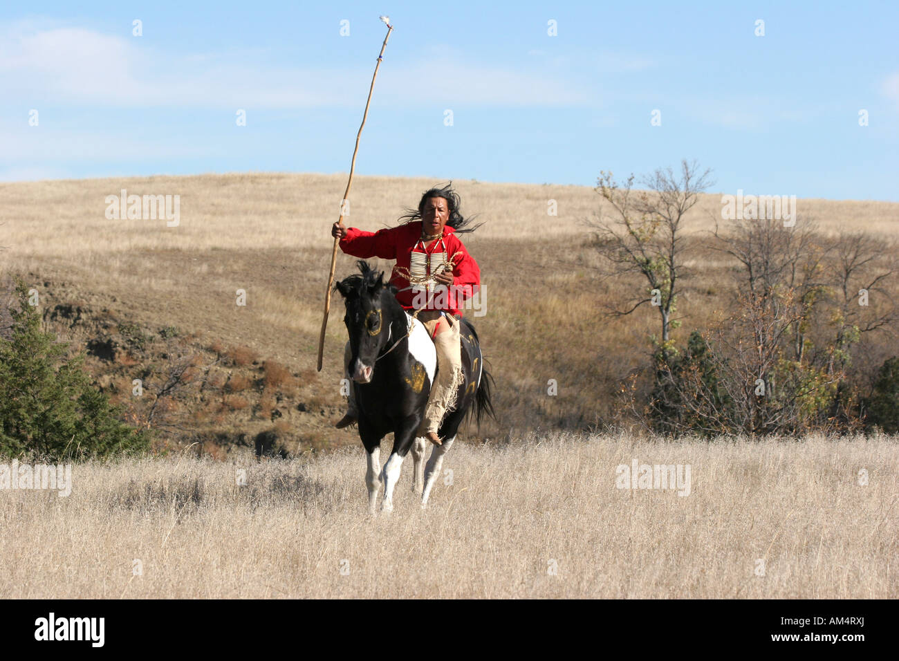 A Native American Indian riding horseback looking for ememies through ...