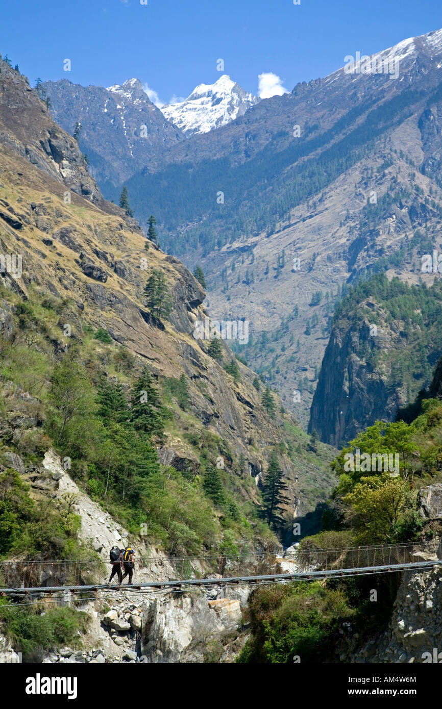Trekkers crossing a hanging bridge over Marsyangdi river. Thonje ...