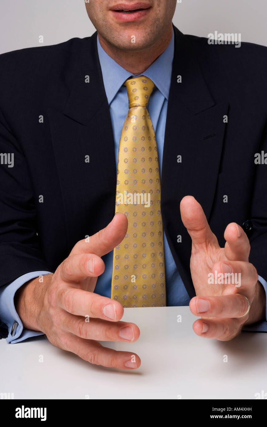 Close shot of business man wearing suit sitting behind desk doing hand ...