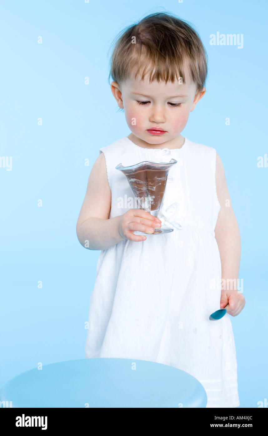 toddler girl eating chocolate pudding Stock Photo - Alamy