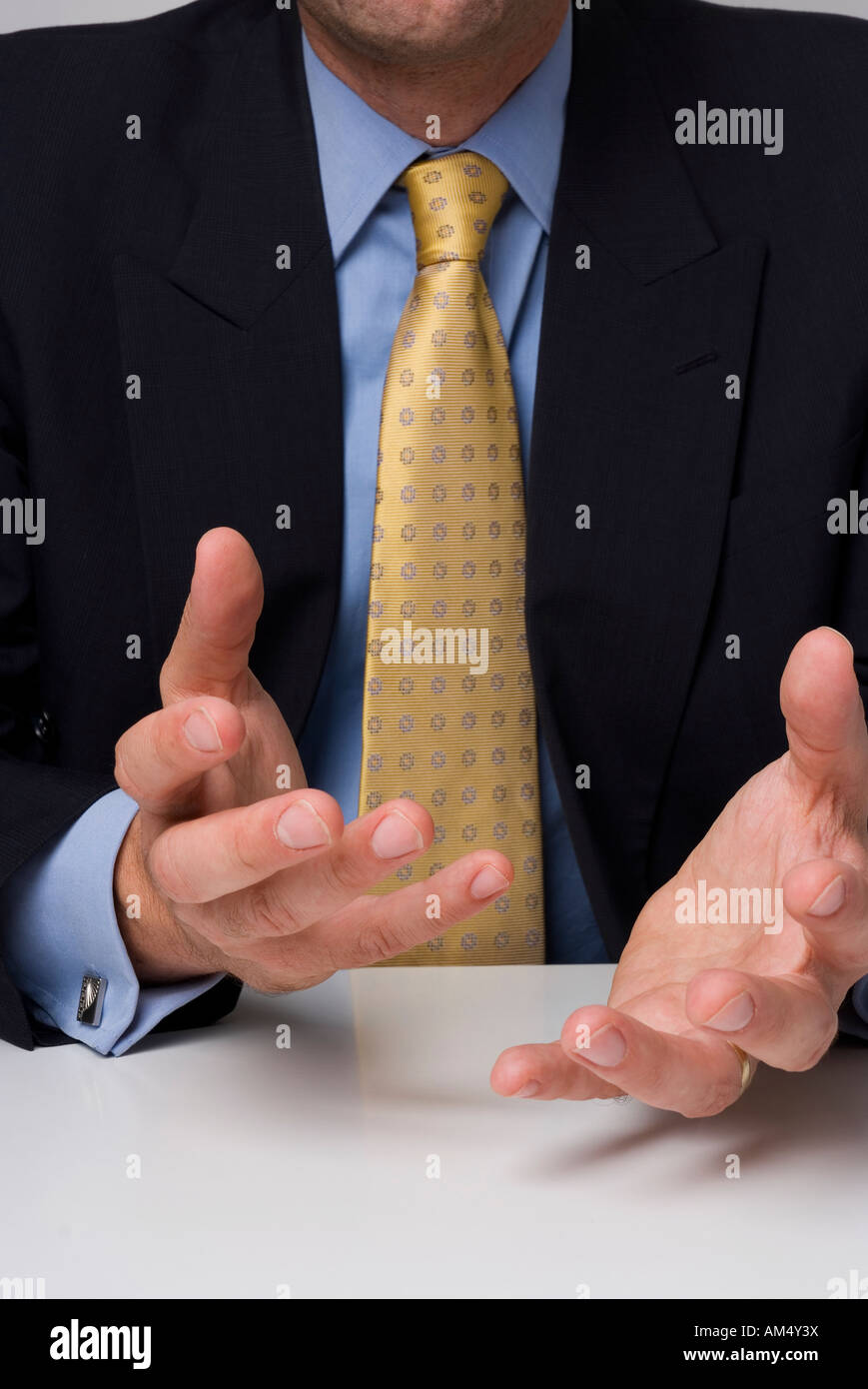 Close shot of business man wearing suit sitting behind desk doing hand ...
