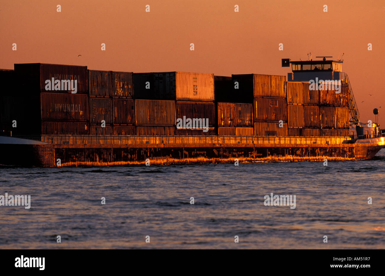 A container ship sailing upstream the Waal river at dusk Stock Photo ...