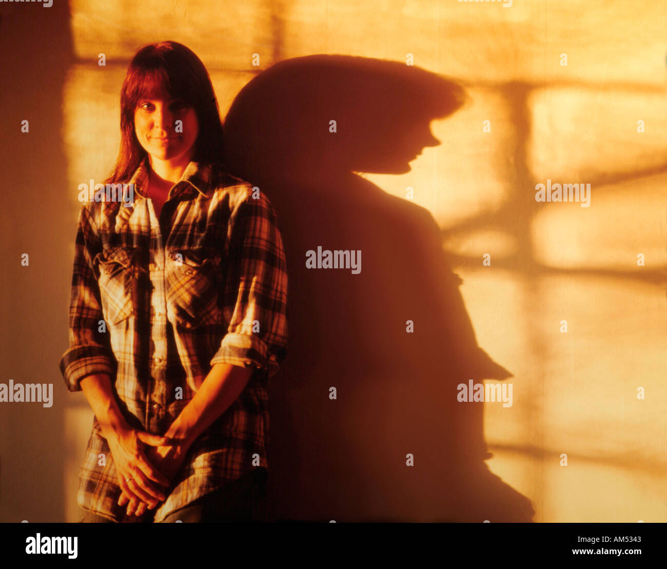 woman standing in late day sunlight by a window Stock Photo - Alamy