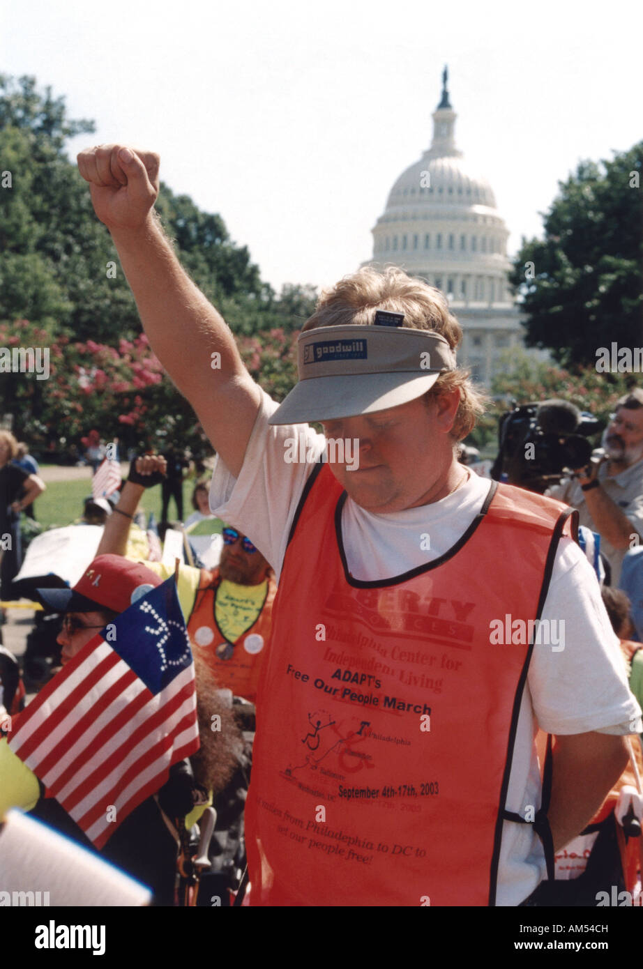 A woman with a disability, raising her arm to show support for advocacy ...