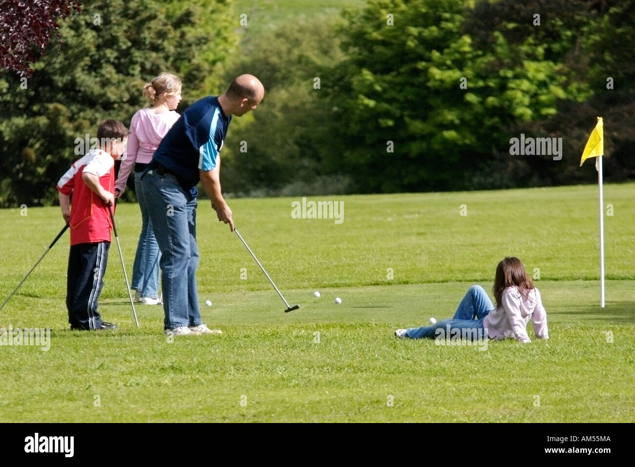 Family playing miniature golf on a sunny day in Mote Park in Maidstone ...