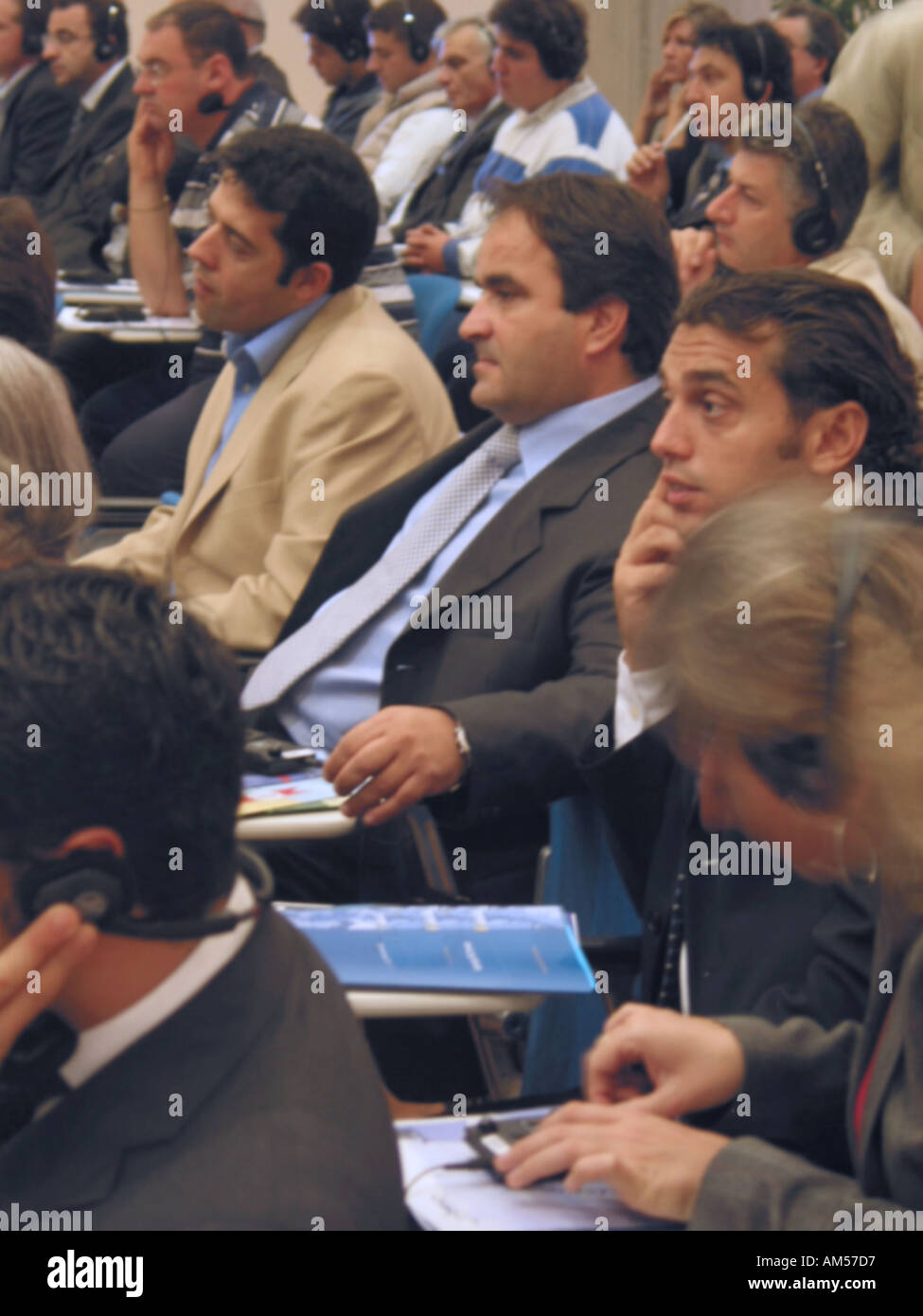 Businessmen at a conference wearing Language Translation Head Phones ...