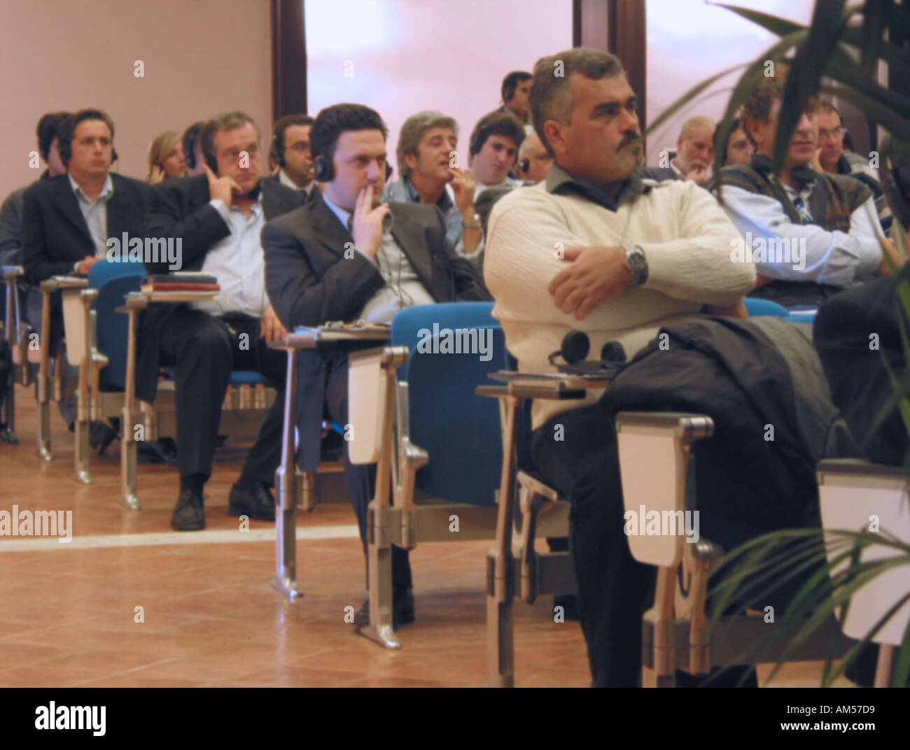 Businessmen at a conference wearing Language Translation Head Phones ...