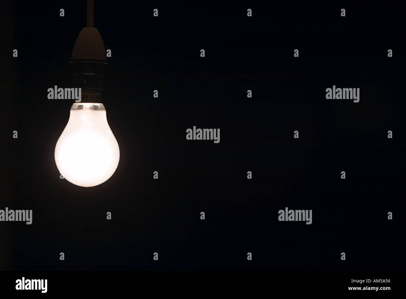 Shining lightbulb against black background Stock Photo - Alamy