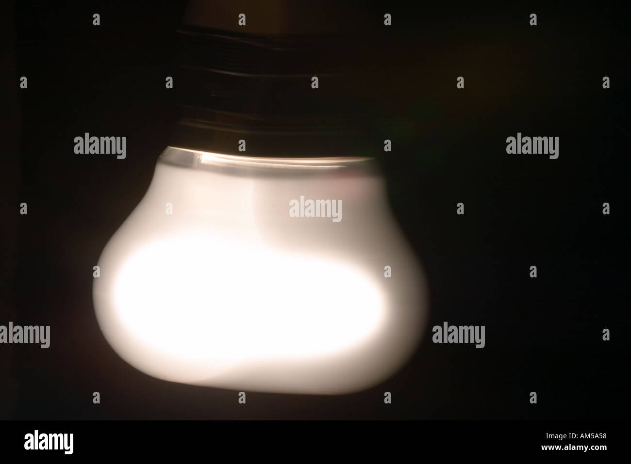 Shining lightbulb swinging against black background Stock Photo - Alamy