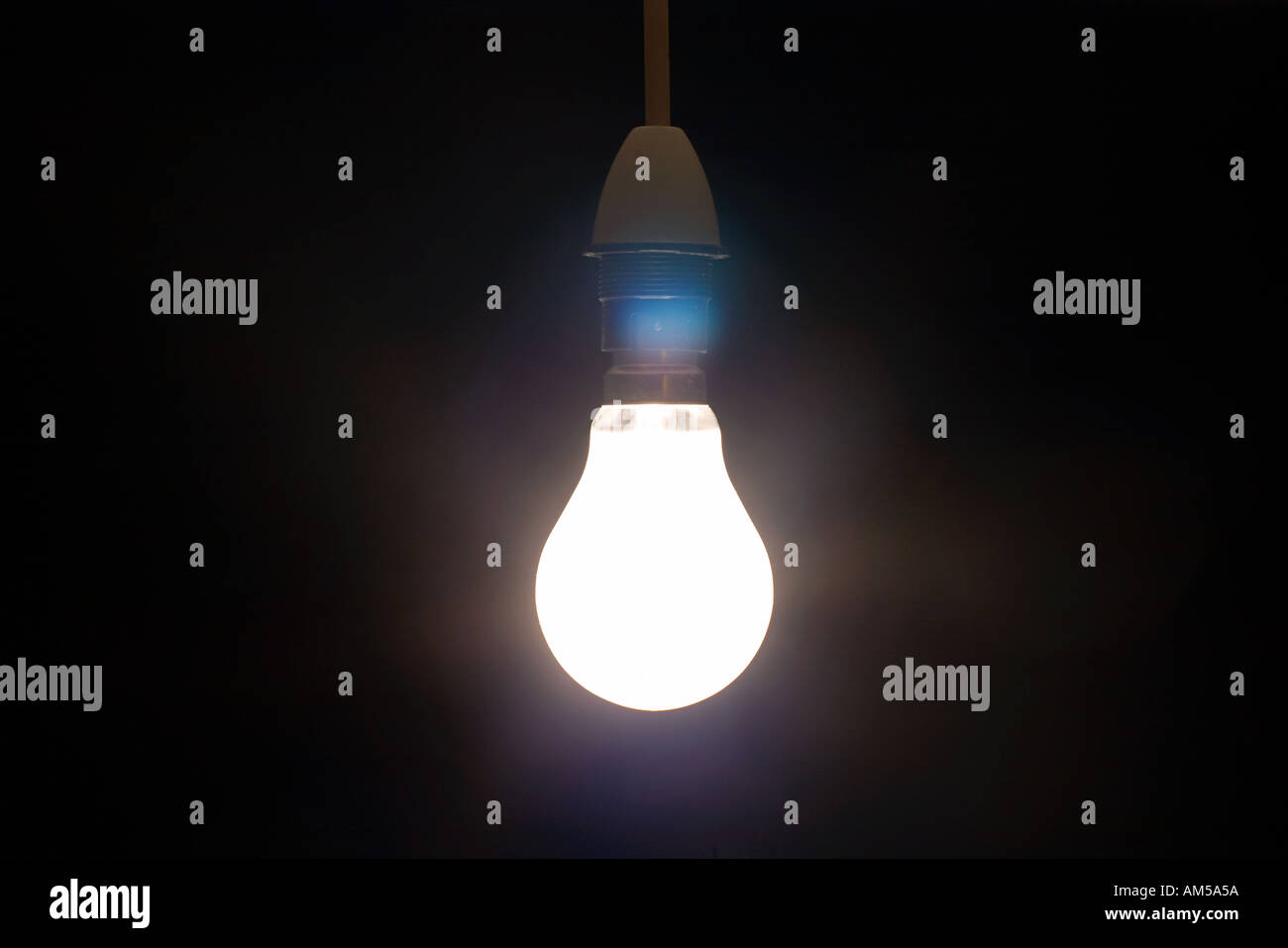 Shining lightbulb against black background Stock Photo - Alamy