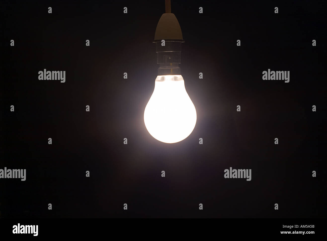 Shining lightbulb against black background Stock Photo - Alamy