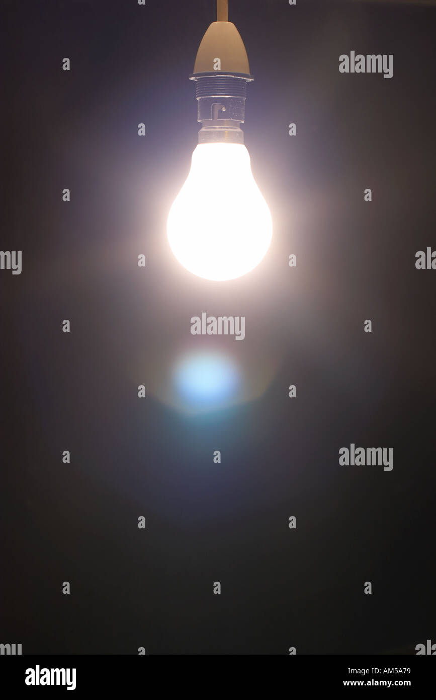 Shining lightbulb against black background Stock Photo - Alamy