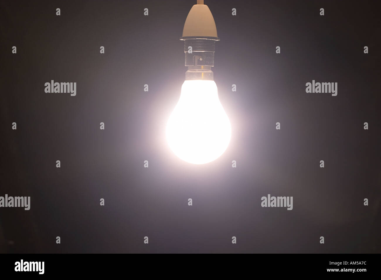 Shining lightbulb against black background Stock Photo - Alamy