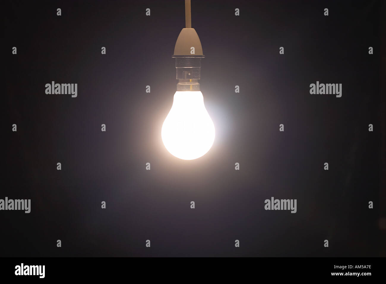 Shining lightbulb against black background Stock Photo - Alamy