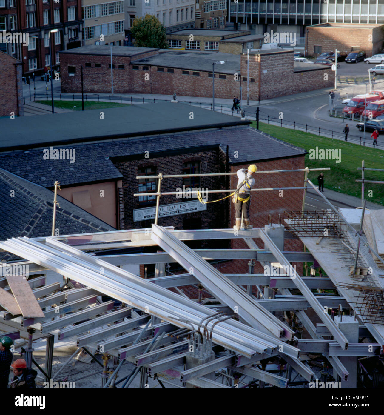 Workman erecting a scaffolding safety barrier, atop the Arndale Centre ...