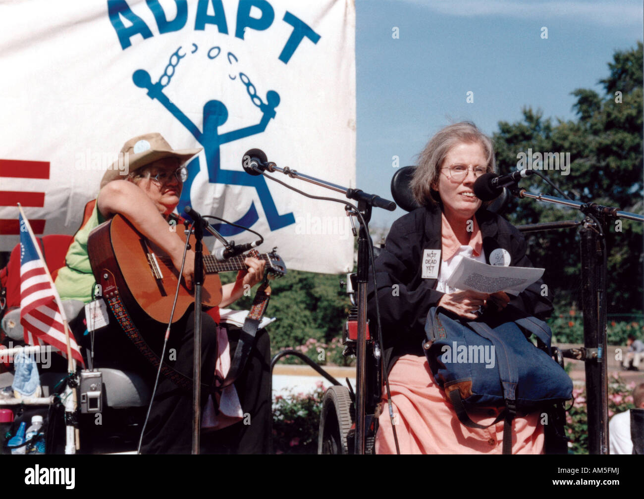 A woman with a disability speaking to a crowd of people with ...