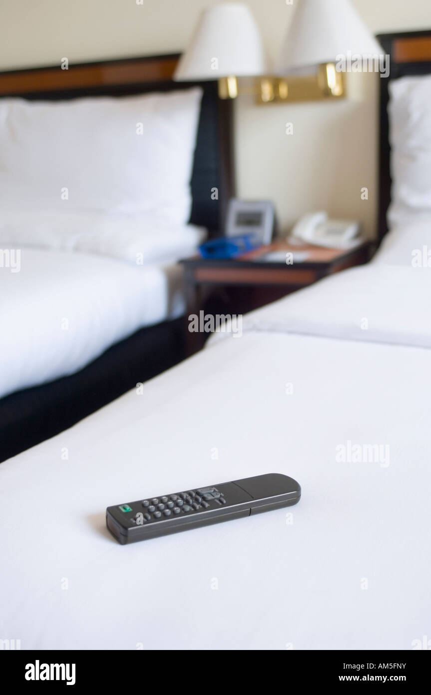Remote control on the bed in a hotel room Stock Photo - Alamy