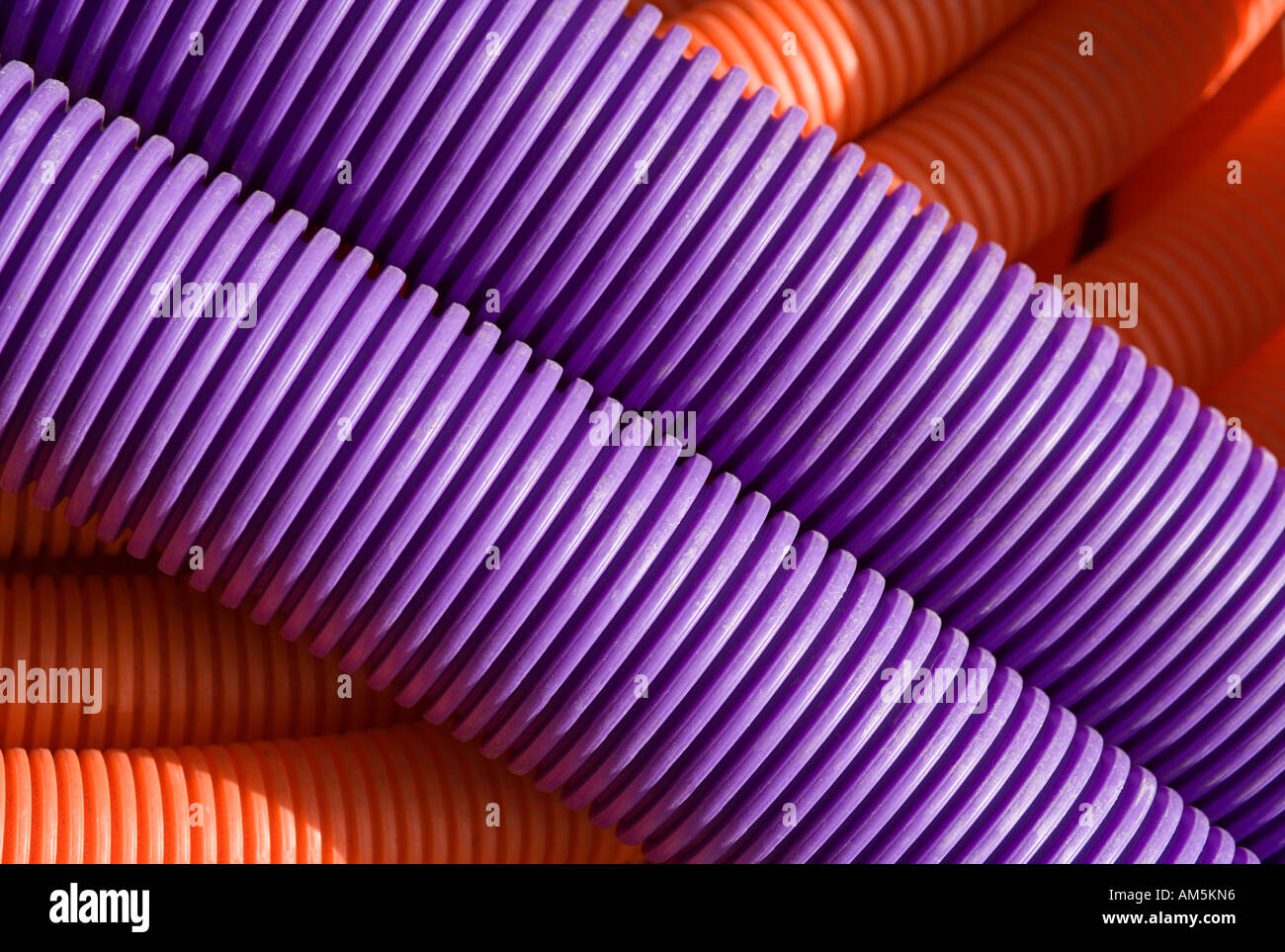 Flexible purple and orange corrugated mantle pipe duct cable coils ...