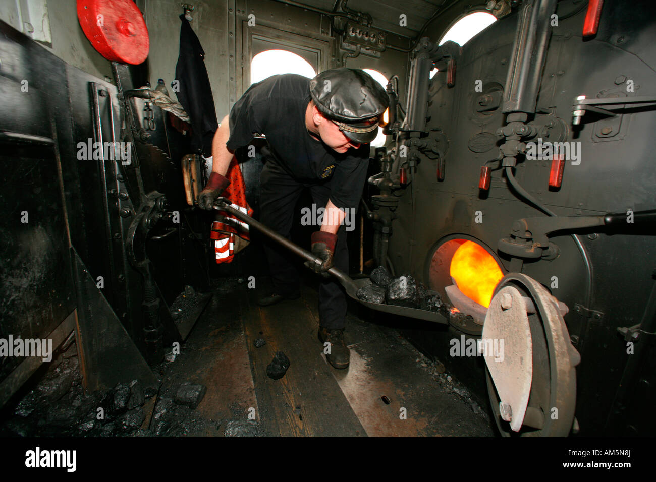 Engine driver fuelling the tank of an historical steam train Stock ...