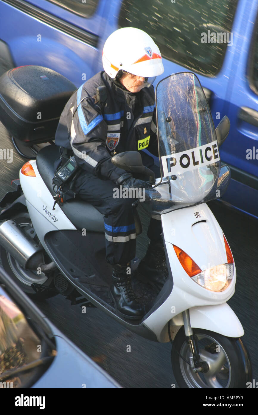 French policeman riding moped through Paris streets, Boulevard Saint ...