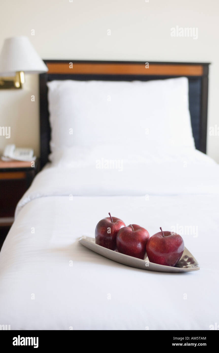 Three apples in a plate on the bed in a hotel room Stock Photo - Alamy
