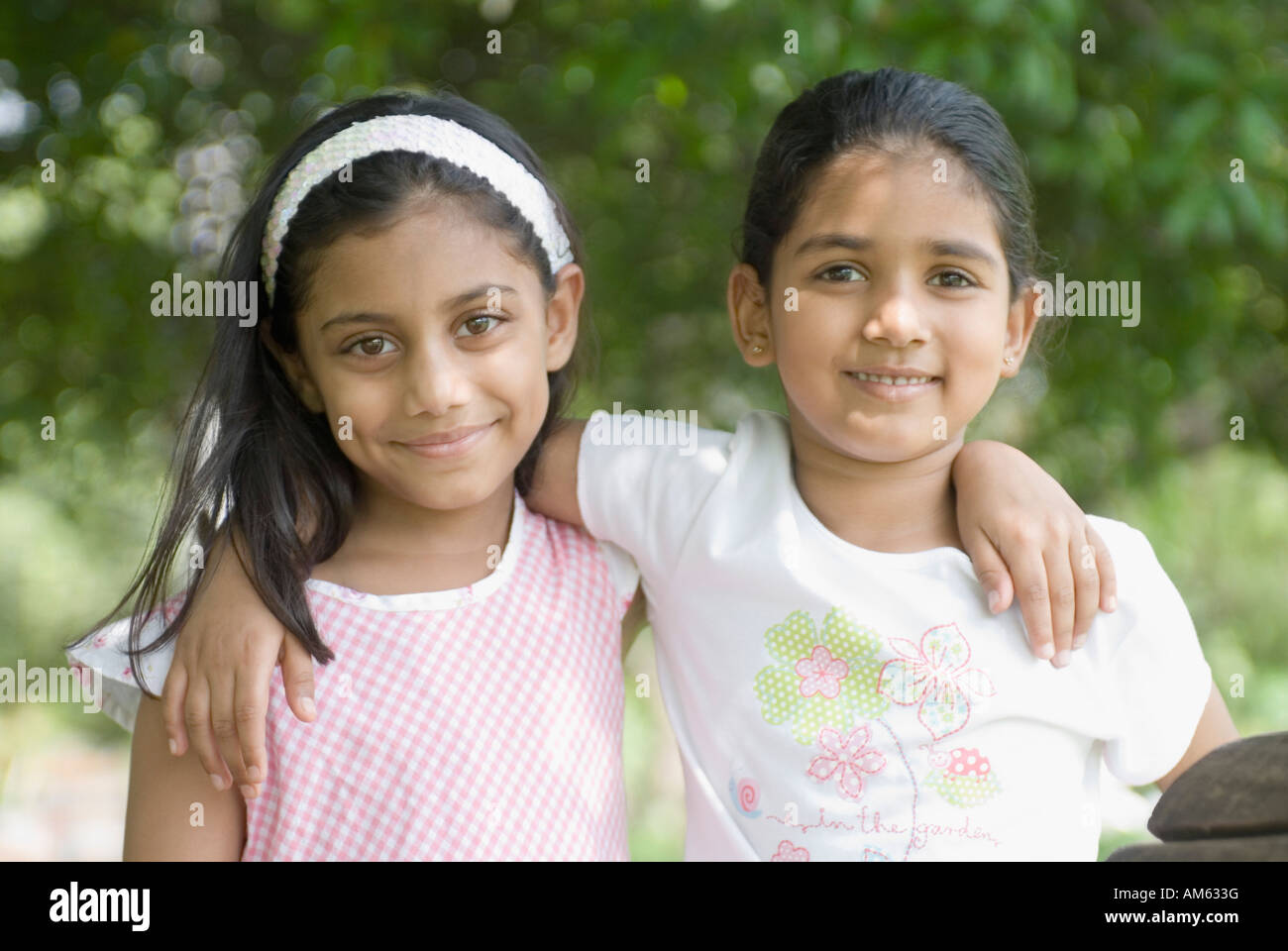 Portrait of two girls standing with their arms around each other Stock ...