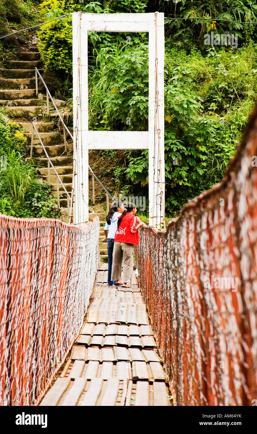 Two girls cross a metal hanging bridge in Banaue Stock Photo - Alamy