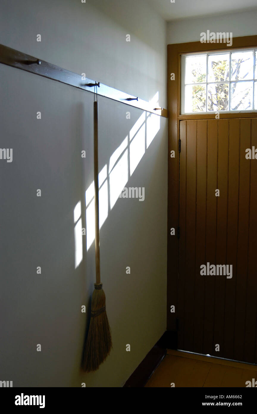 Exterior door in hallway of Shaker house with broom hanging on peg on ...
