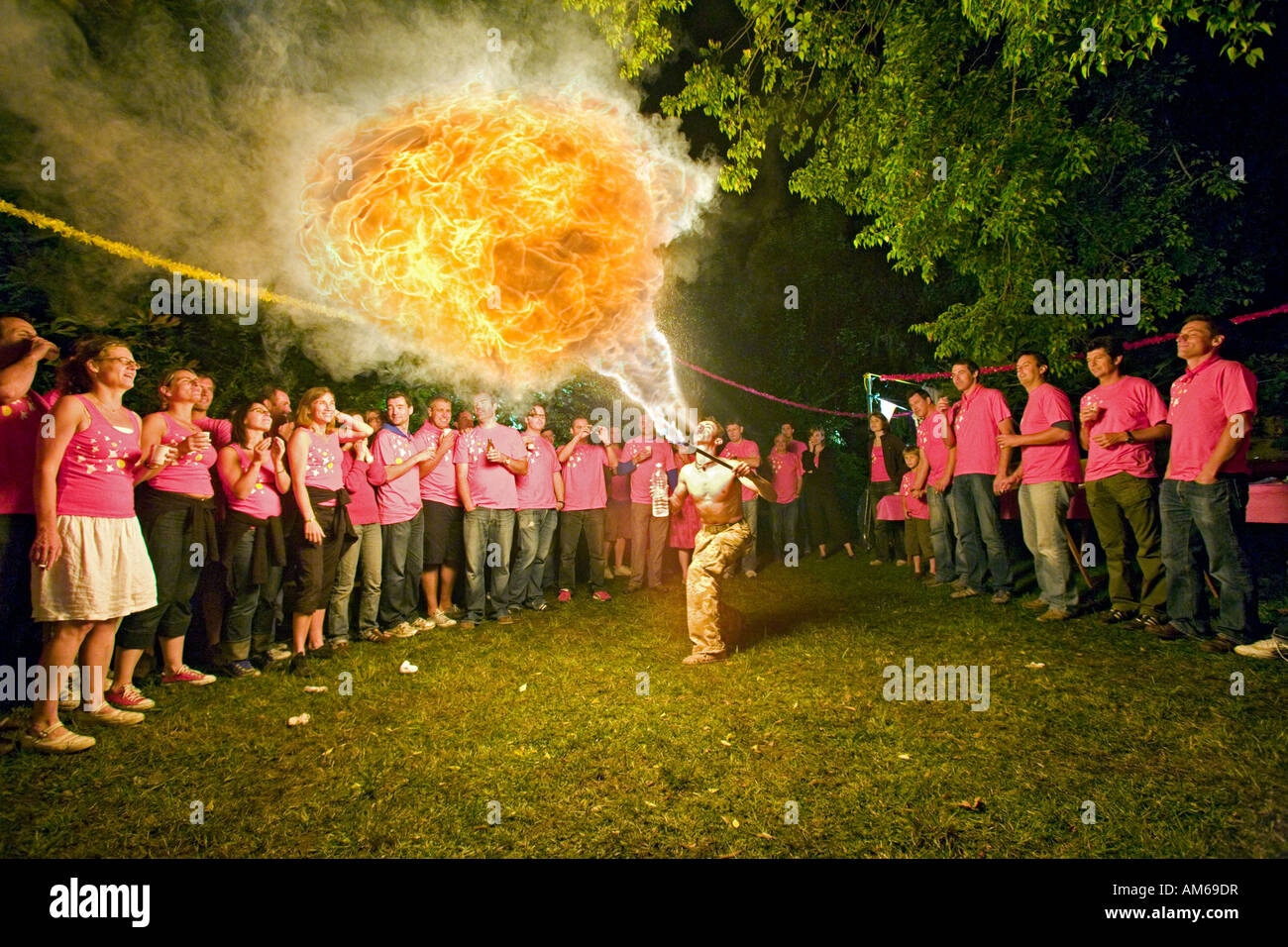 A fire-eater giving a demonstration before an admiring gathering ...