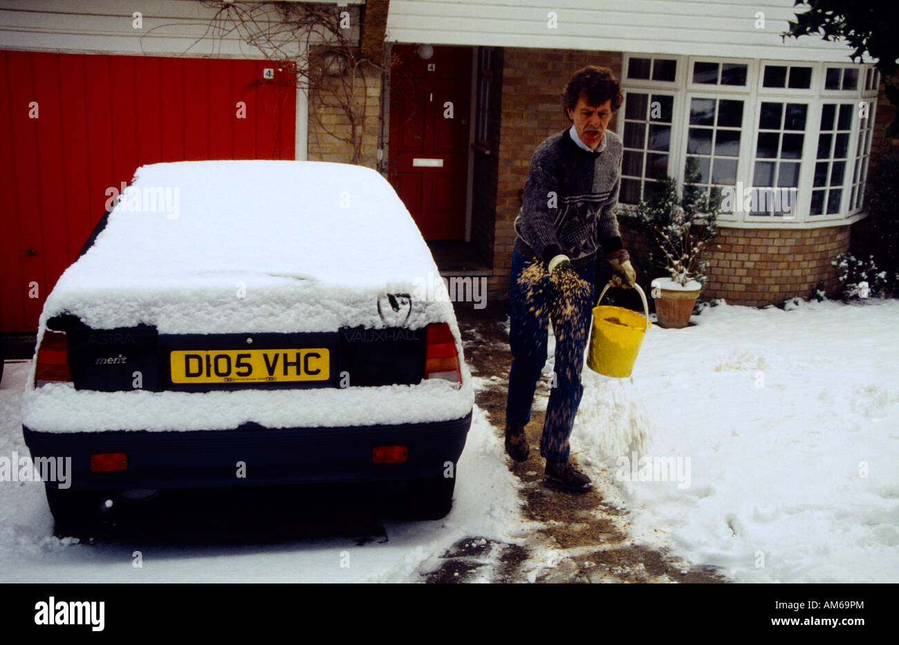 Man Gritting Path In The Snow Stock Photo - Alamy