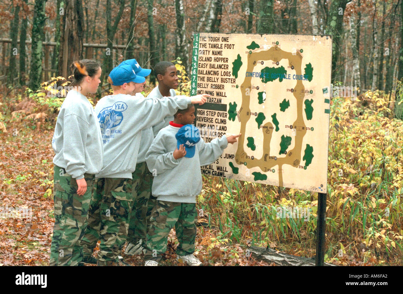 Teenagers age 14 looking at map of confidence course at youth retreat ...