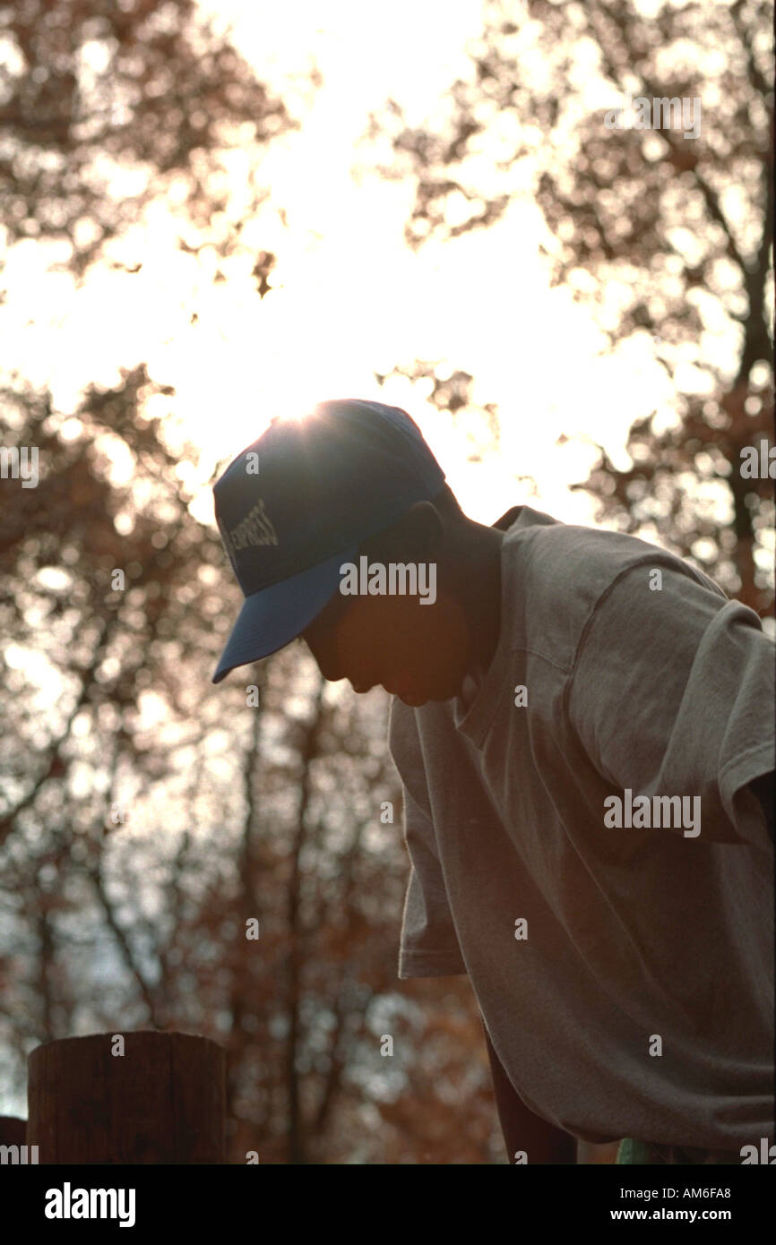 Boy age 14 relaxing on obstacle course at youth center retreat. Camp ...
