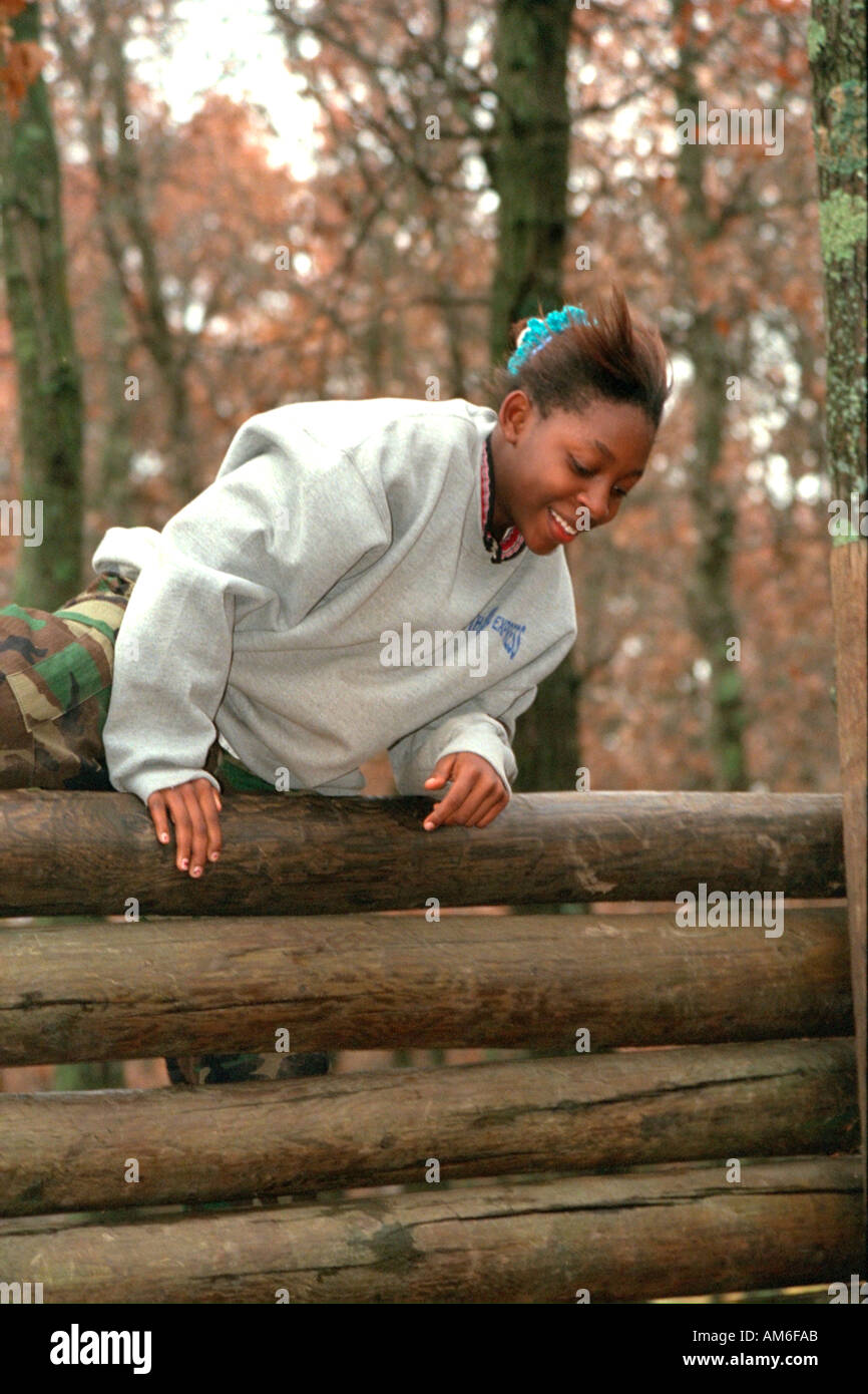 African American girl age 14 jumping log wall in obstacle course at ...