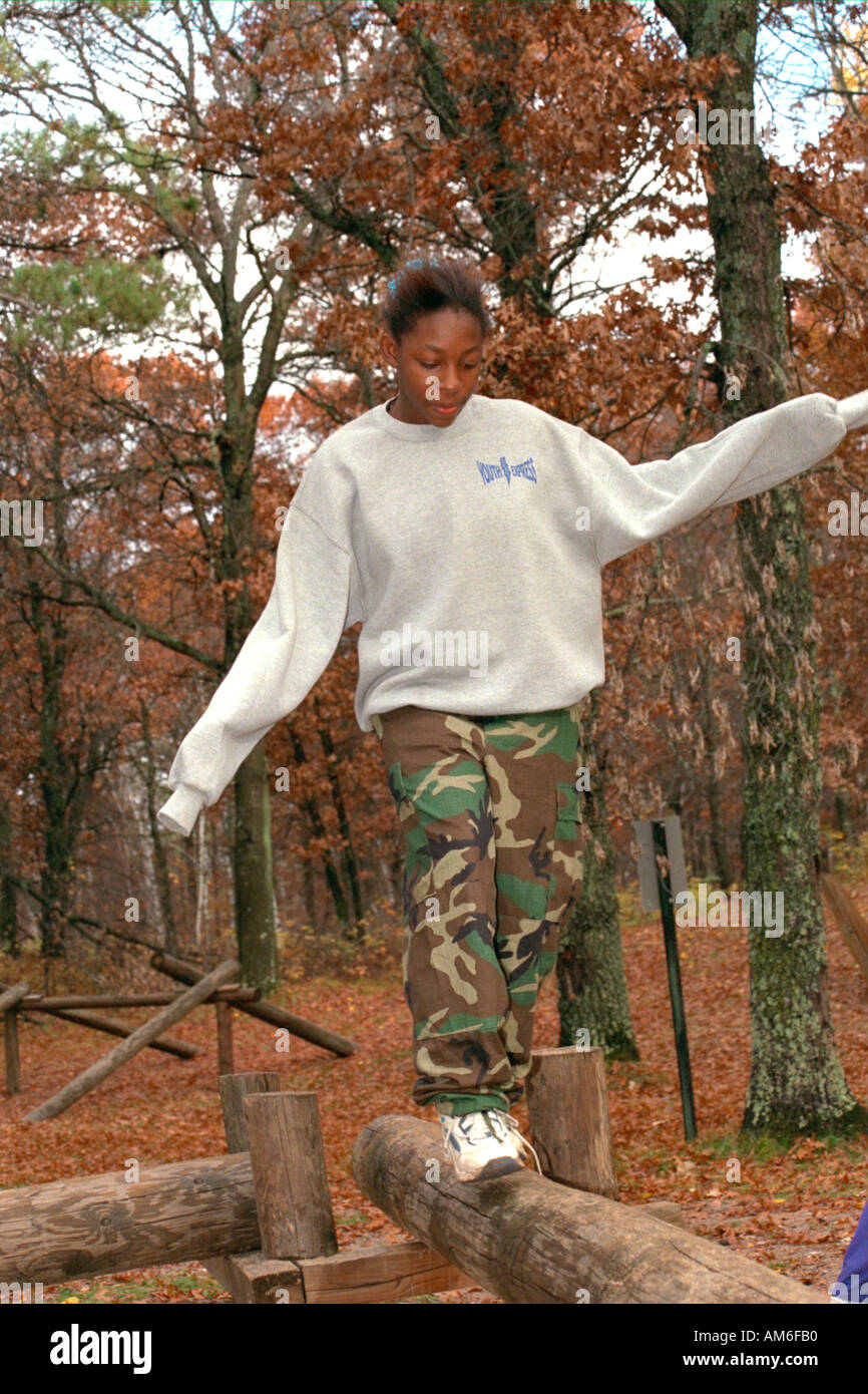 Girl age 14 walking balance beam in obstacle course at youth retreat ...