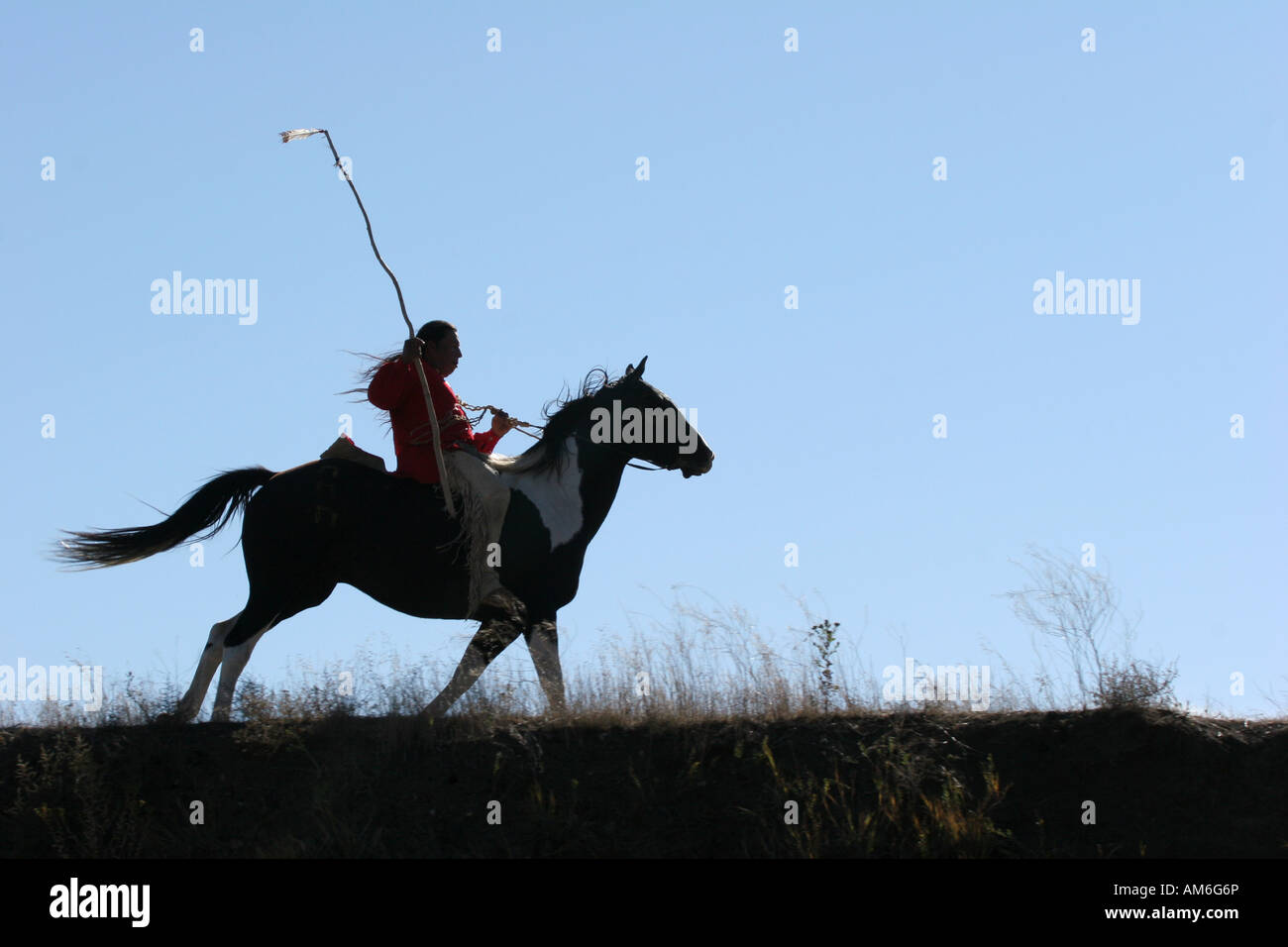 A Native American Indian riding horseback looking for ememies through ...