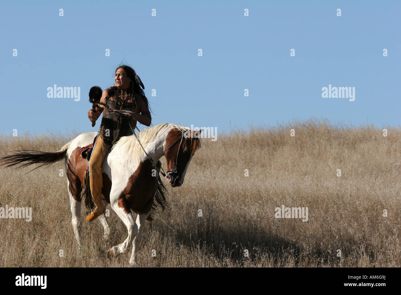 A Native American Indian riding horseback looking for ememies through ...