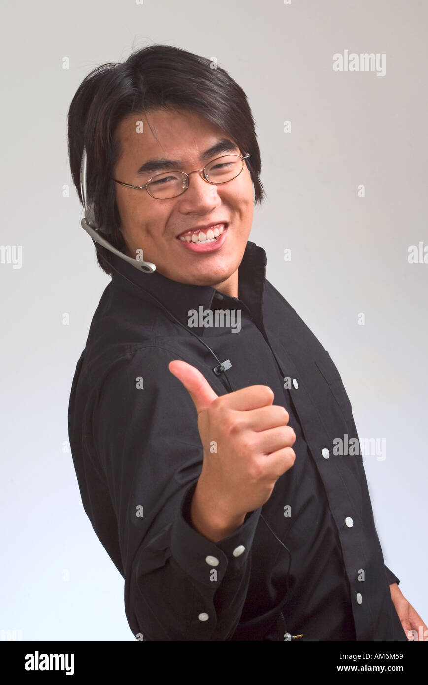 Male call center rep giving thumbs up sign depicting successful sale ...