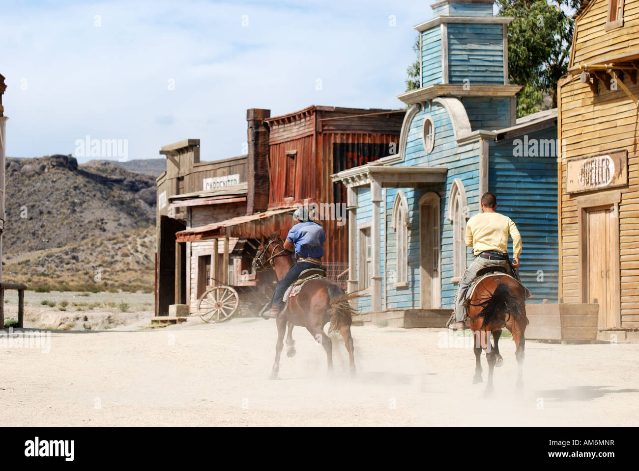Two cowboys riding away in a traditional American western style town ...