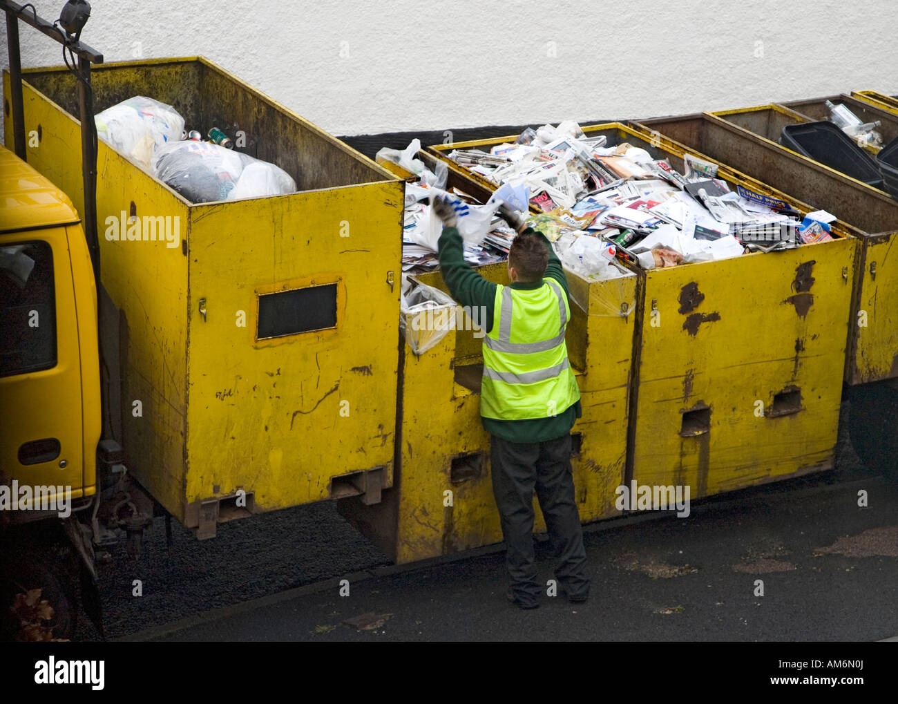 Workman emptying paper into recycling lorry used for kerbside rural ...