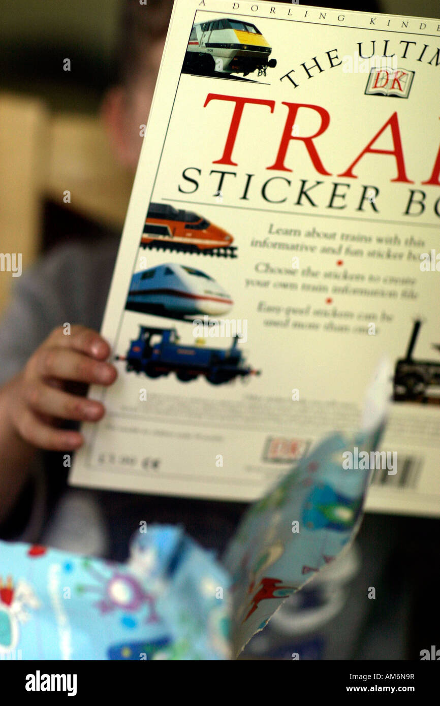 six-year-old boy reading a train sticker book Stock Photo - Alamy