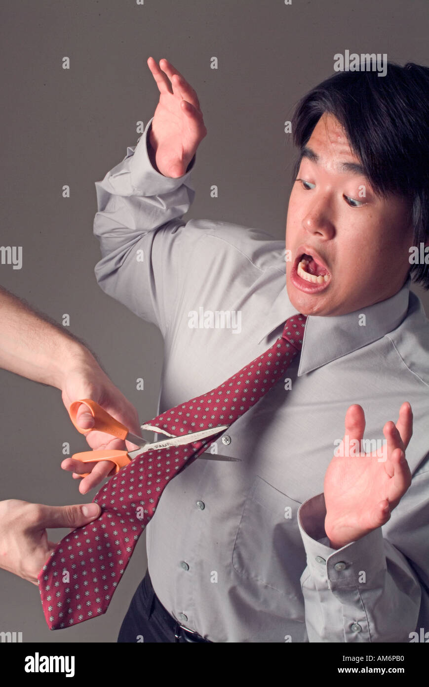 Scissors cutting tie of shocked Asian businessman Stock Photo - Alamy