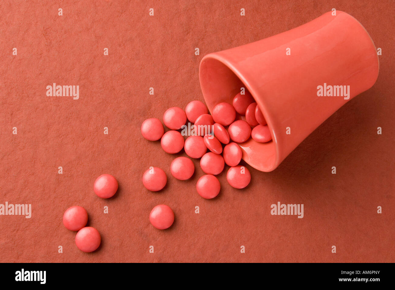 Candies spilling from a plastic glass Stock Photo - Alamy