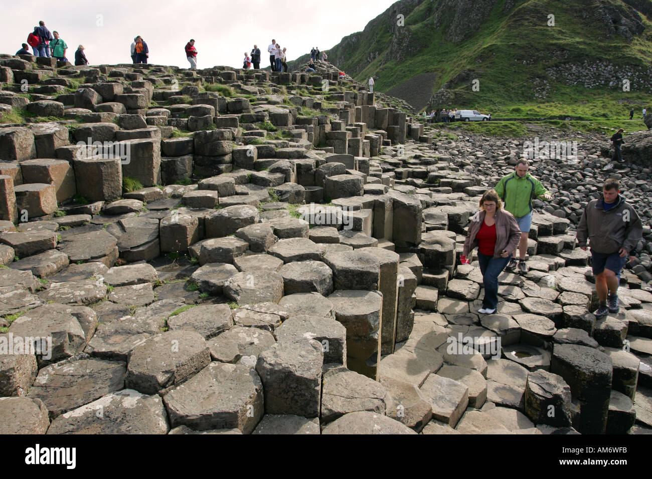 Tourists walk over the spectacular hexagonal basaltic rocks of the ...