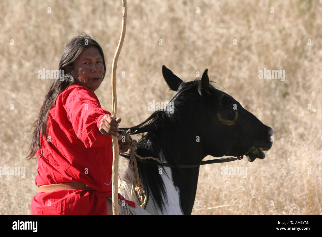A Native American Indian riding horseback looking for ememies through ...