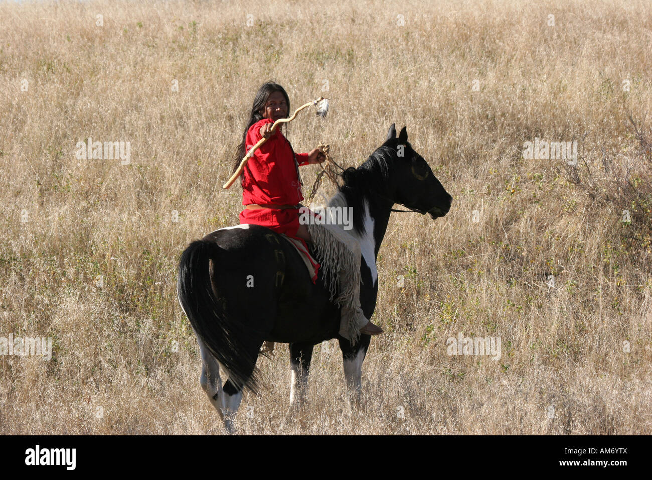 A Native American Indian riding horseback looking for ememies through ...