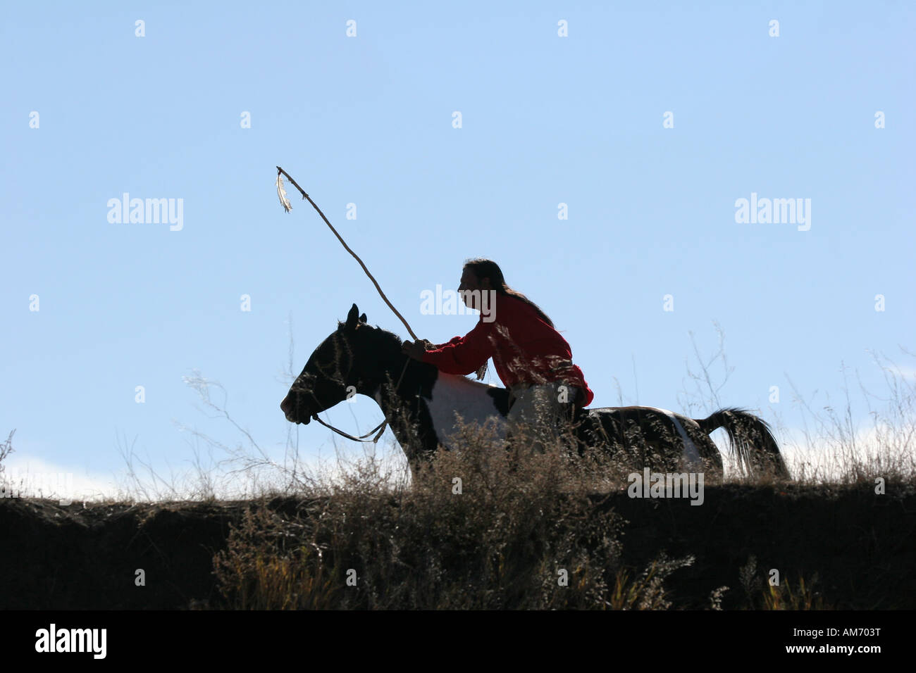 A Native American Indian riding horseback looking for ememies through ...