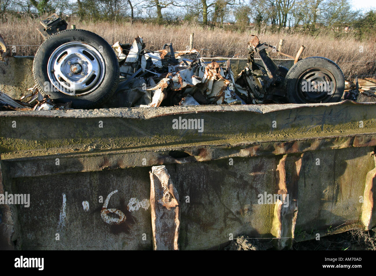 A wrecked car recovered from waste land and thrown in a skip Stock ...