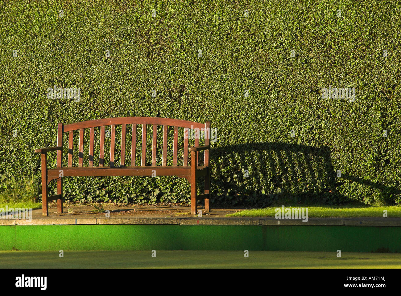 Early morning sun and shadow on an empty bench Stock Photo - Alamy