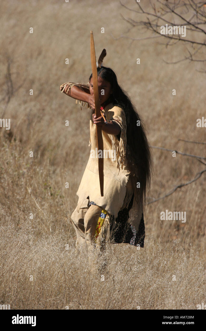 A young Native American Indian boy using or hunting with a bow and ...